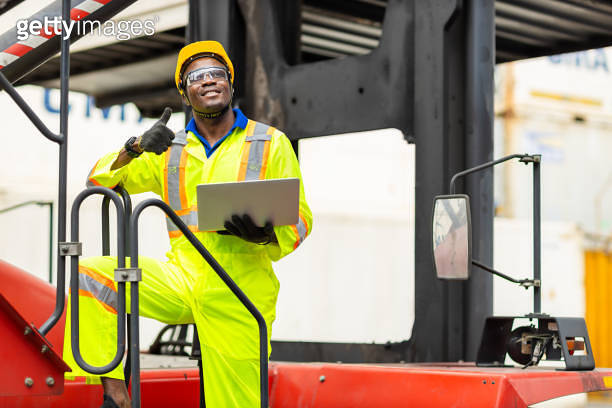 African male dock worker control loading containers cargo at warehouse ...