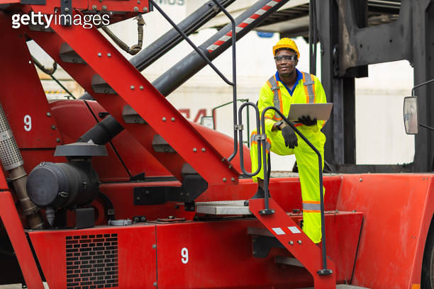 African male dock worker control loading containers cargo at warehouse ...