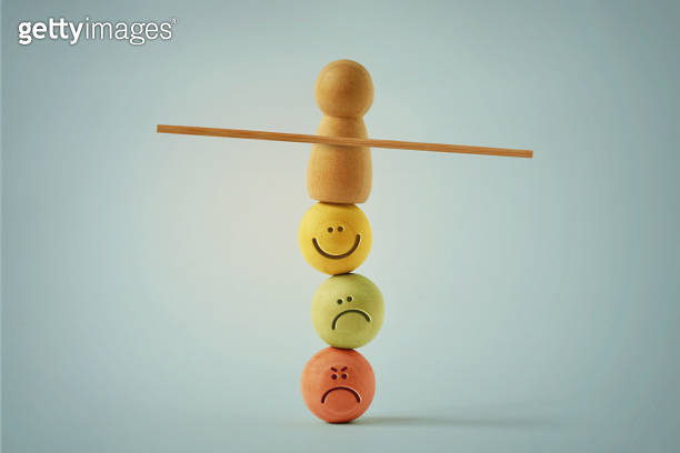 Wooden pawn balancing on beads faces with different mood expressions ...