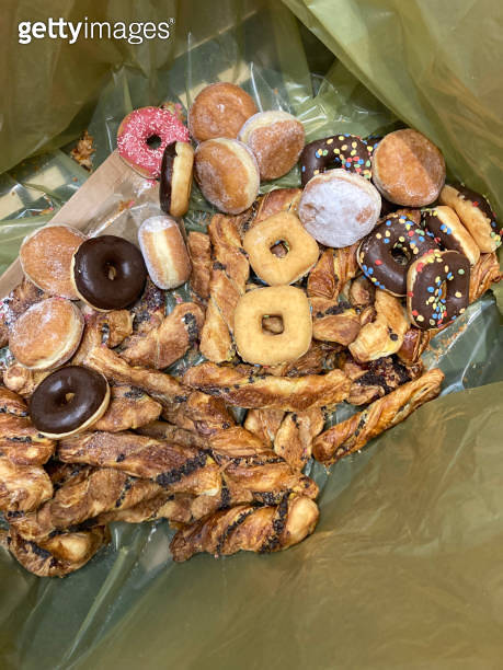 Large number of cakes, biscuits and pastries dumped into a waste ...