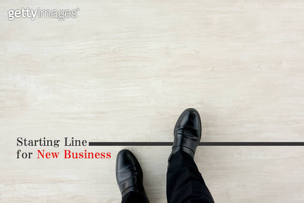 Business man's feet stepping over starting line for new business ...