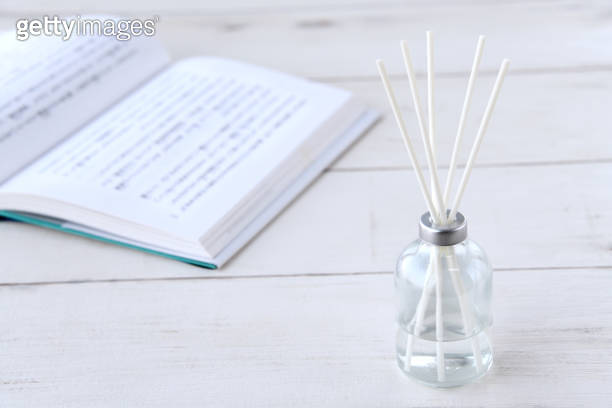 Reed diffuser and opened book on natural white wooden desk 이미지 ...