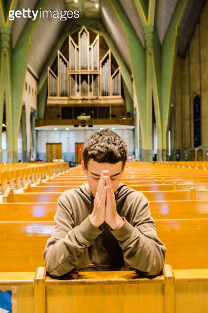 Teenage boy praying in Notre Dame Sanctuary (1494342412) - 게티이미지뱅크