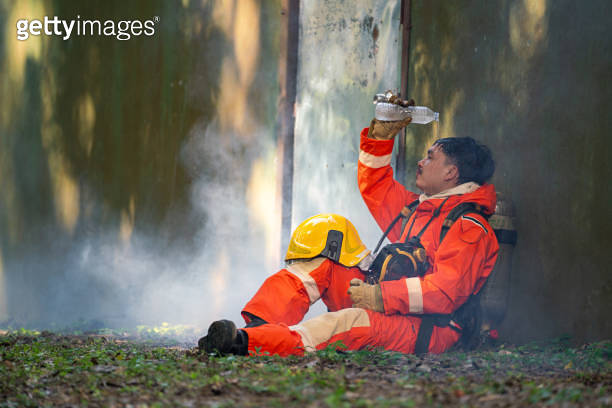 Firefighter Resting and Drinking Water After a Grueling Rescue ...