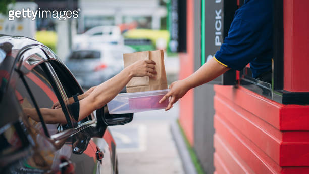 Young Man receiving coffee at drive thru counter., Drive thru and take ...