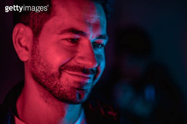 Male portrait of man with neon lighting. Red, blue, purple and magenta ...