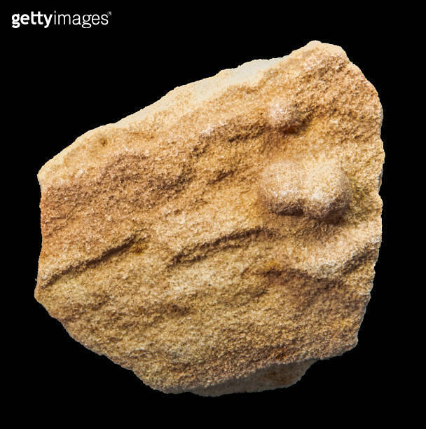 Magnified close up of a wavy bumpy sandstone rock with a mineral crust ...