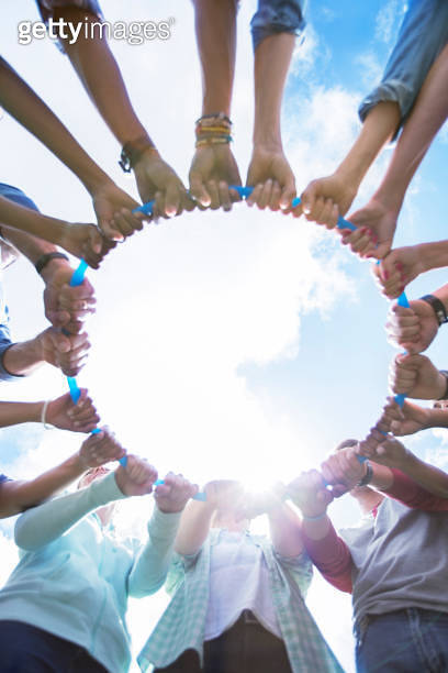 Team forming connected circle around plastic hoop 이미지 (554392053) - 게티이미지뱅크