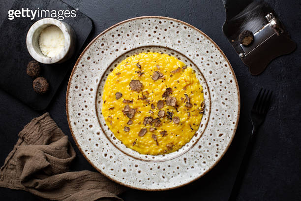 Saffron risotto with delicious black truffles and hard cheese. Tuber ...