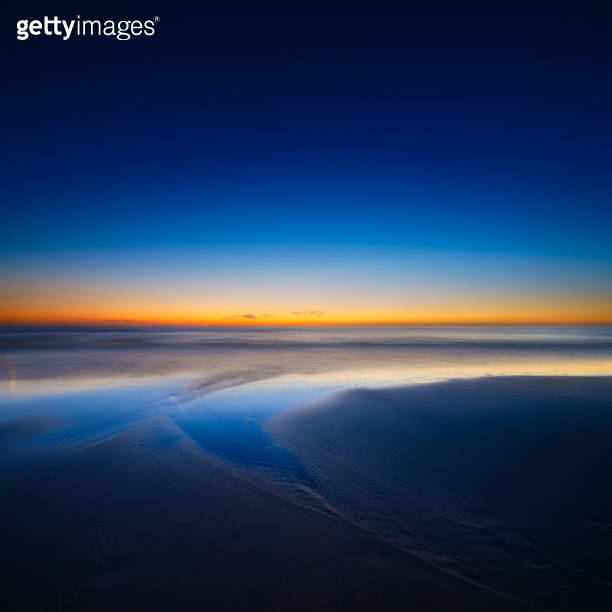 A seascape during sunset. Lines of sand on the seashore. Bright sky ...