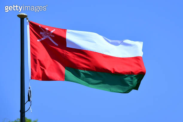 Flag of Oman on a black flagpole over clear sky - actual photo (not CGI ...