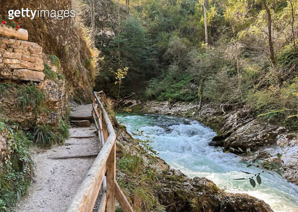 Hiking trail in a canyon with a beautiful river with azure water on a ...