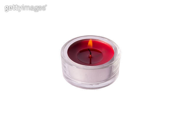 Burning red scented tea candle in glass candle holder. Isolated on ...