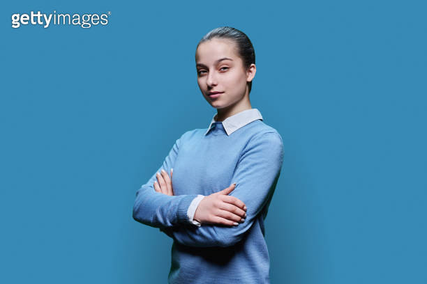 Portrait of serious high school student girl on blue background 이미지 ...