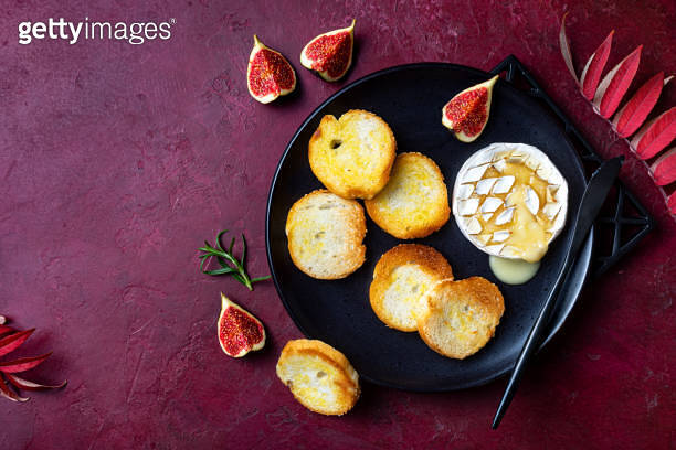 Baked Brie or Camembert cheese with toasted bread and fresh figs. Fall ...