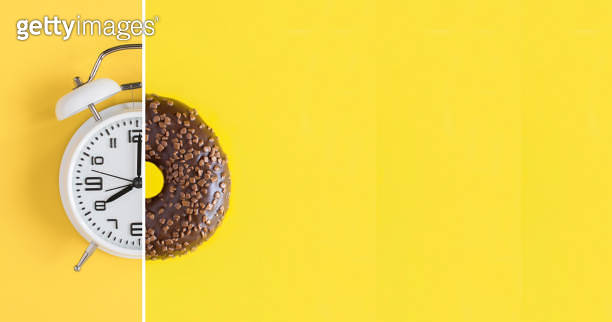 Collage of white alarm clock and donut with chocolate glaze on the ...