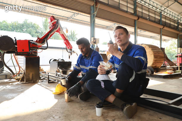 Happy teamwork technician engineer in safety workwear having lunch and ...