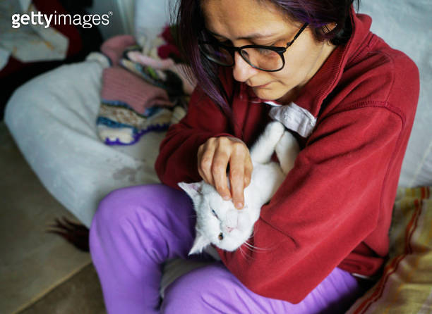 Young woman enjoying a cuddle with her cat 이미지 (1464014535) - 게티이미지뱅크