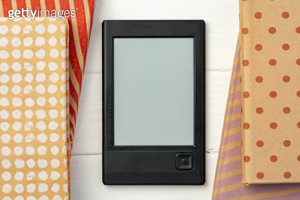 E-book reader device on background of paper books 이미지 (1513449969) - 게티 ...