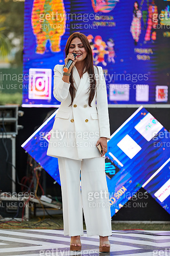 Indian woman singer in white clothes sings the song at outdoor stage of ...