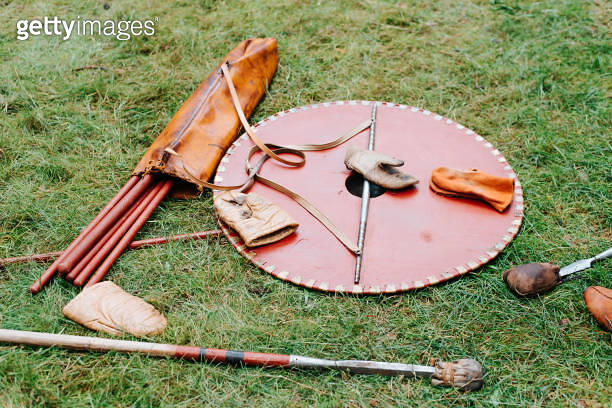 Medieval weapons and an ancient round wooden shield lying on green ...