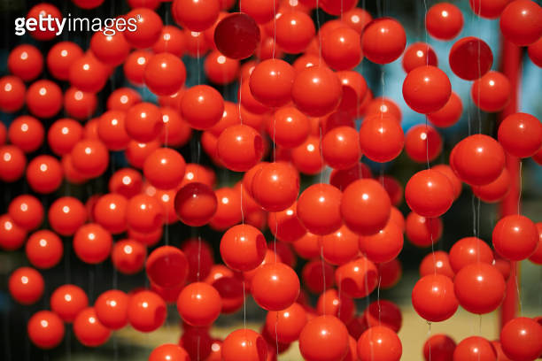 Red balls suspended on wire, outdoor art object symbolizing blood cells ...