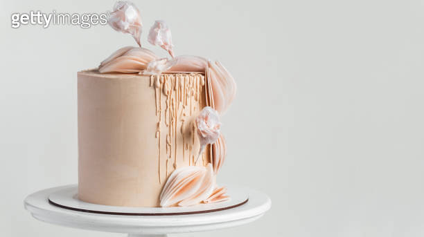 Beautiful big cake with beige chocolate icing decorated with edible ...
