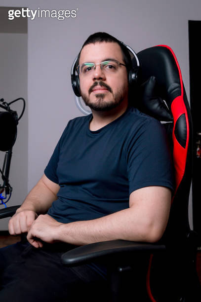 young gamer man sitting looking at the camera tired of playing so much ...