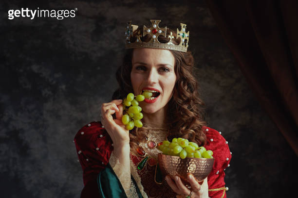 medieval queen in red dress with plate of grapes and crown (1633403355 ...