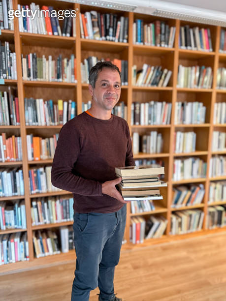 Librarian holding books in the library 이미지 (1806059499) - 게티이미지뱅크