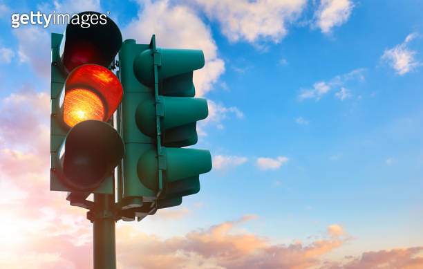 Green traffic light with burning yellow lamp supervisory road. T ...