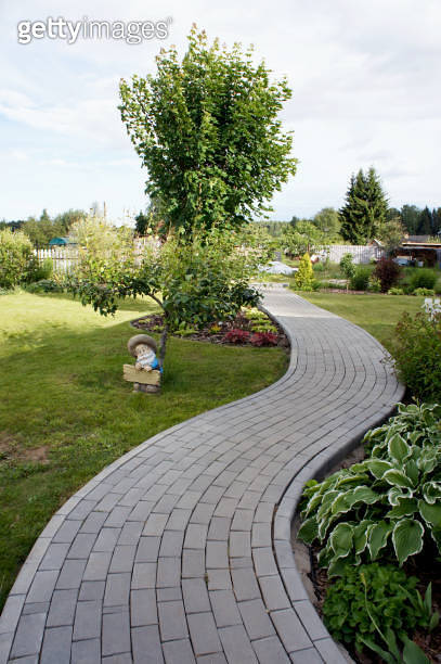 Curved Pathway from gray bricks in the garden. Decorative Landscaping ...