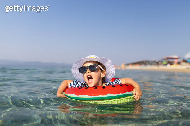 Fashionable young girl in inflatable watermelon float, shouting in ...