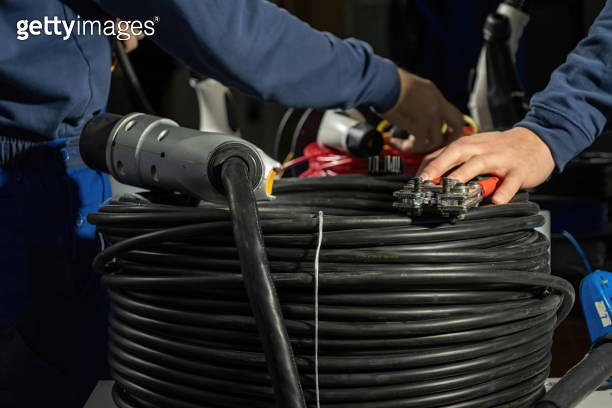 Electricians install cables in plug to charge EV on stations 이미지 ...