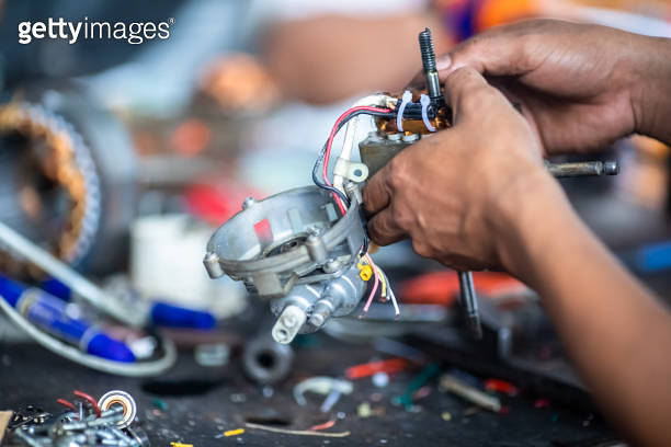 Selective focus to tools and hand of an electric motor repairman ...