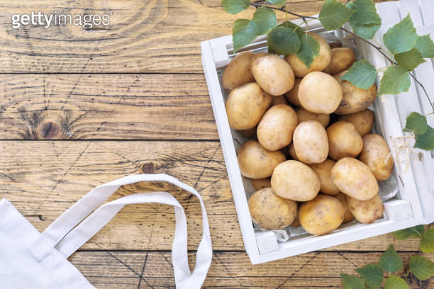 Wooden box full of young, organic, farm potatoes from the local market ...