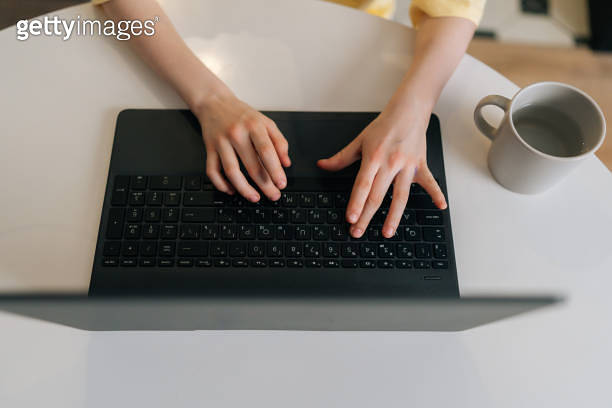 Closeup high-angle view of unrecognizable pupil school boy typing on ...