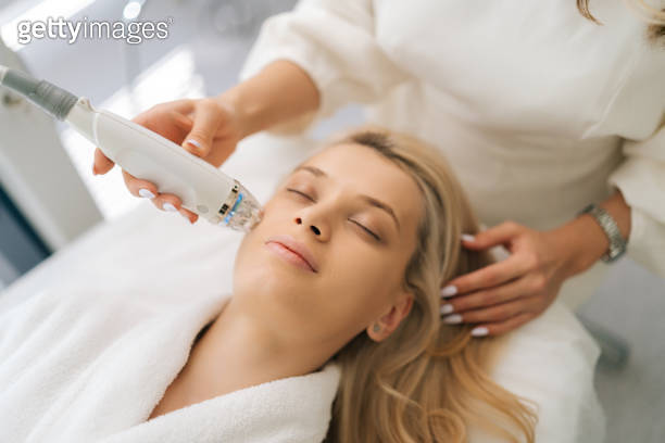 Close-up high-angle view face of blonde woman client lying with closed ...