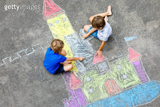 Two little kids boys drawing knight castle with colorful chalks on ...