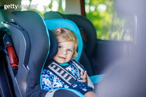 Adorable baby girl with blue eyes sitting in car safety seat. Toddler ...