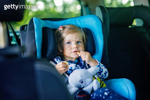 Adorable baby girl with blue eyes sitting in car safety seat. Toddler ...