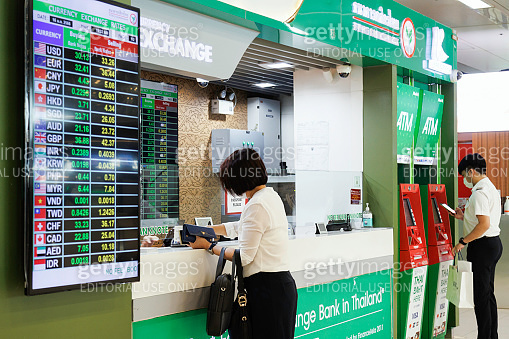 asian business traveler in bank money exchange counter at suvarnabhumi ...