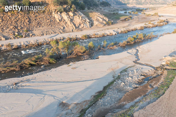 Muddy stream in mountain canyon. River after flooding in early summer ...