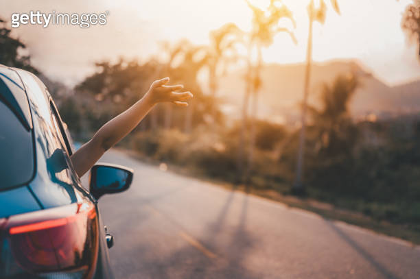 Happy woman hand out window car blue and driving on country road into ...