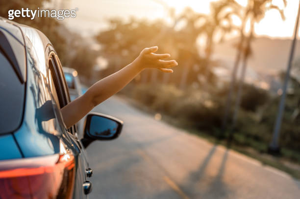Happy woman hand out window car blue and driving on country road into ...