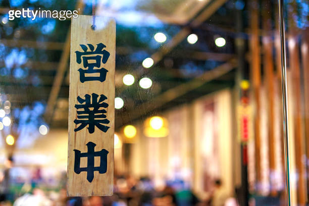 A Chinese character 'open' sign on a restaurant hangs on the door at ...