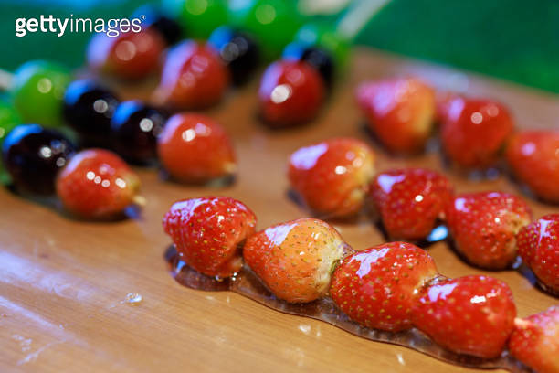 Sugar-coated fruit on a stick also known as “Tanghulu", popular street ...