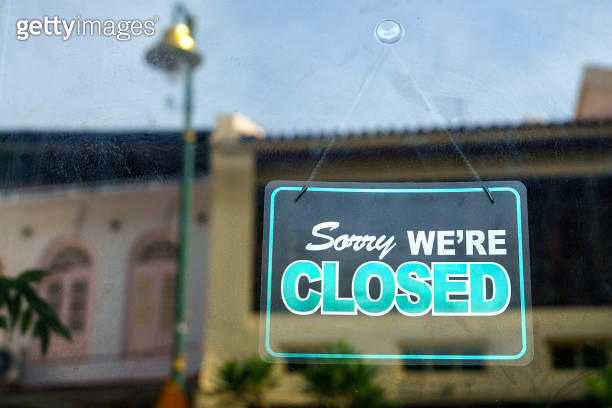 View through window of closed sign in a modern retail store ...