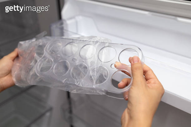 Close-Up Hands Removing Plastic Wrap Of A Egg Tray In Refrigerator ...