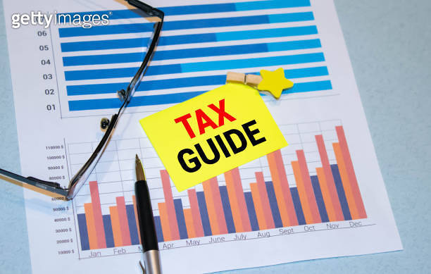 yellow card with text TAX GUIDE on tax forms 이미지 (1467125902) - 게티이미지뱅크